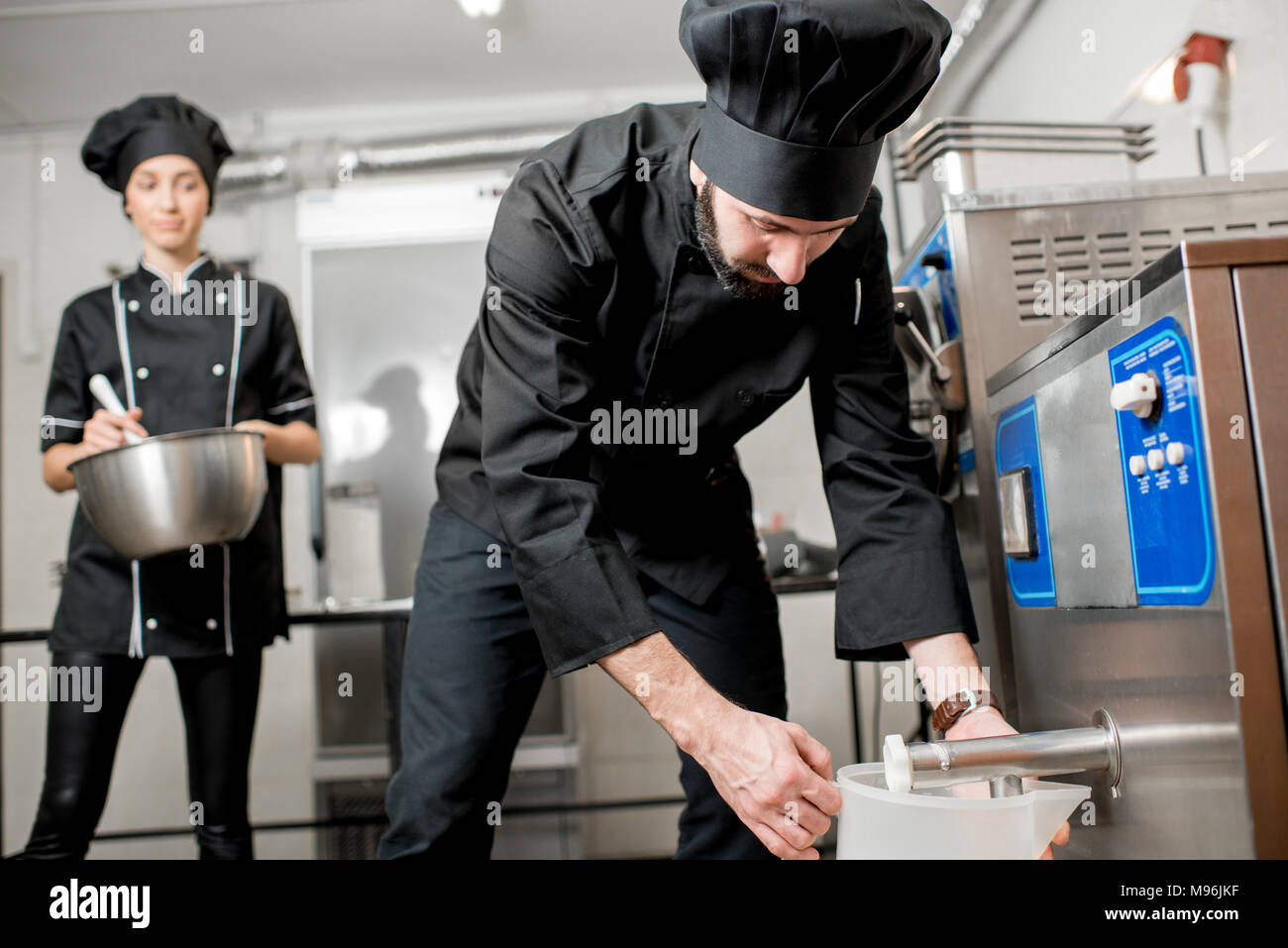Chef pouring pasteurized milk into the jar for ice cream production ...