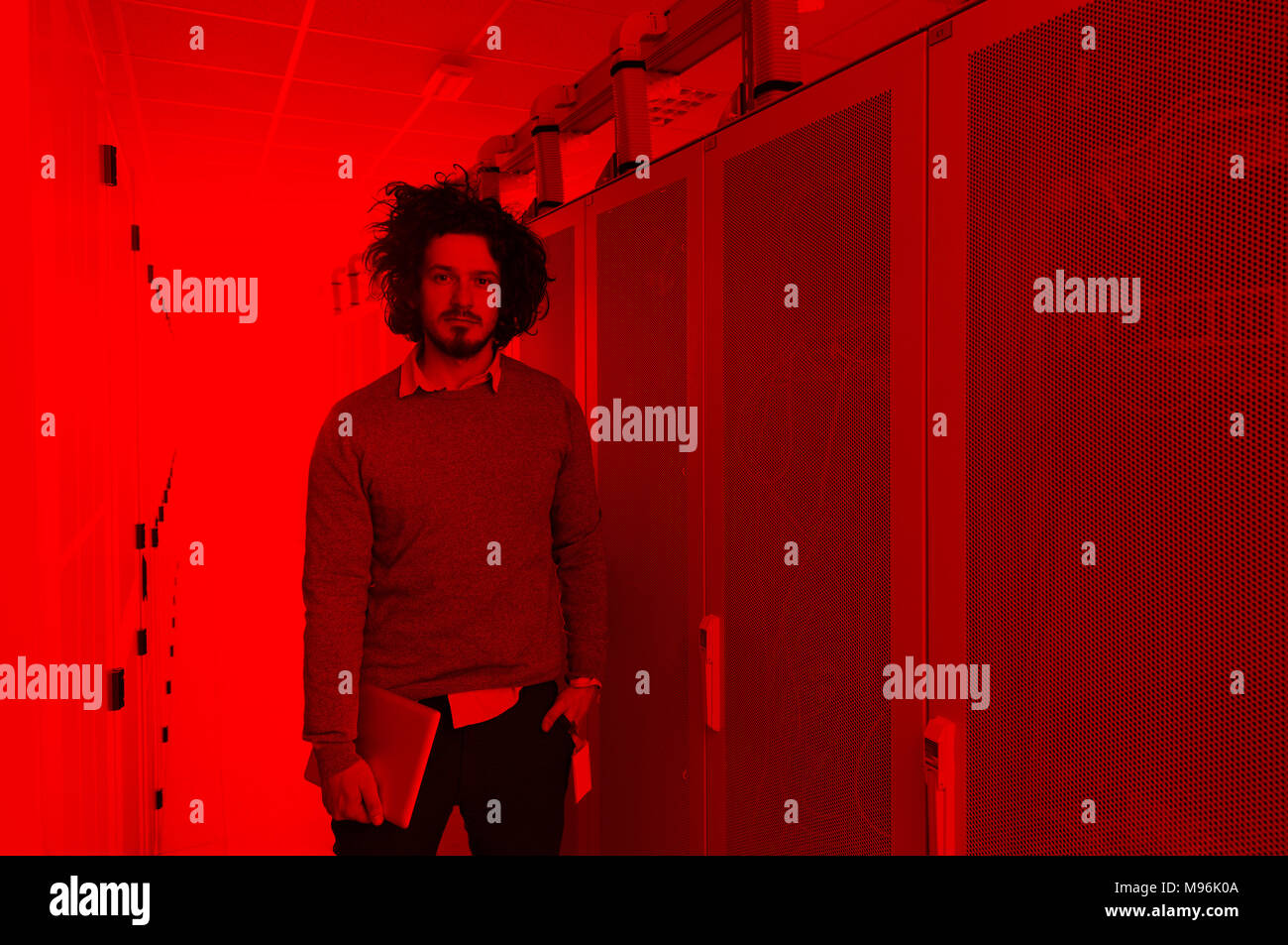Male IT engineer working on a tablet computer in server room at modern ...