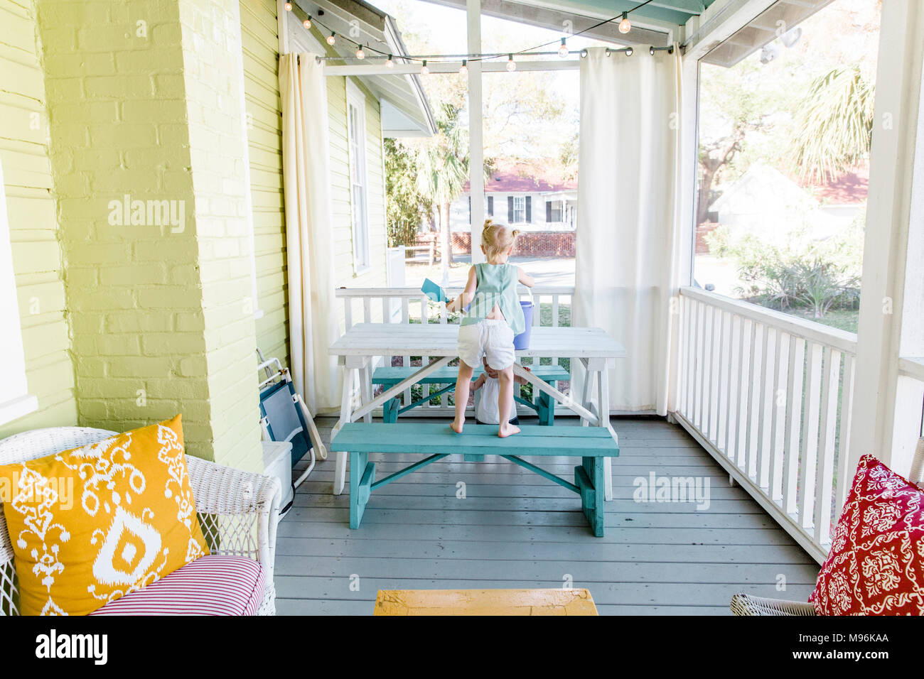 Girl standing on bench on porch Stock Photo - Alamy
