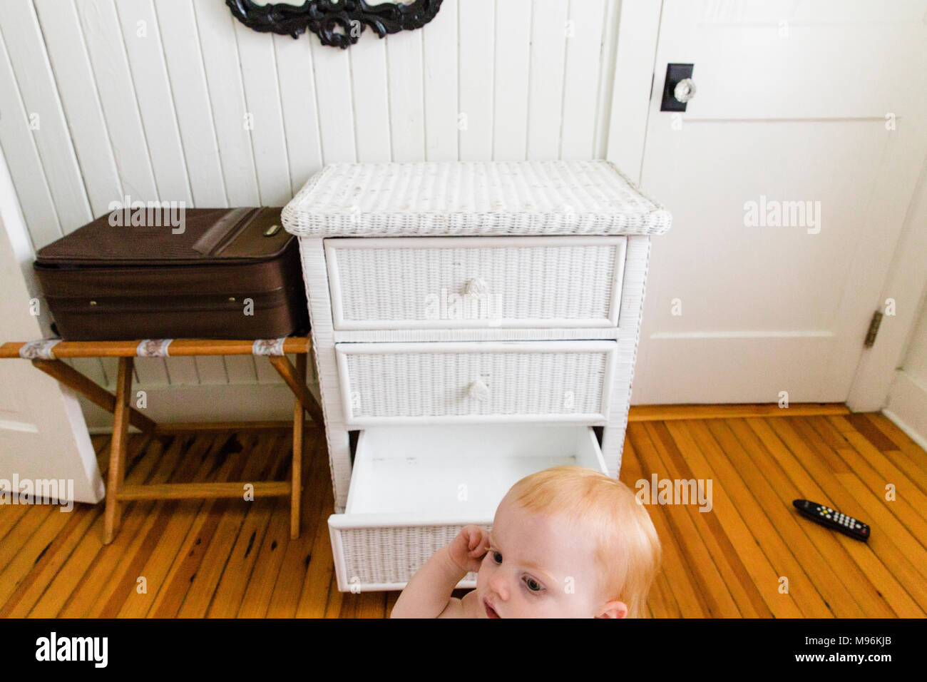 Baby alone in room with open drawer Stock Photo - Alamy