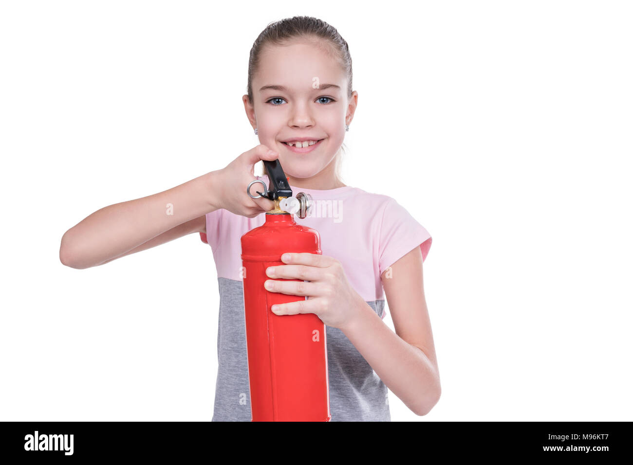 Young girl holding a fire extinguisher in her hands and ready to use it ...