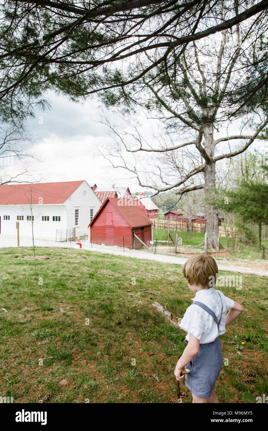 Boy standing outside of barn Stock Photo - Alamy