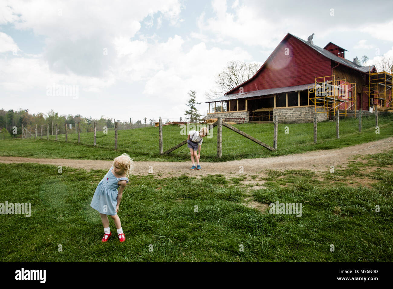 Two children outside of barn Stock Photo - Alamy