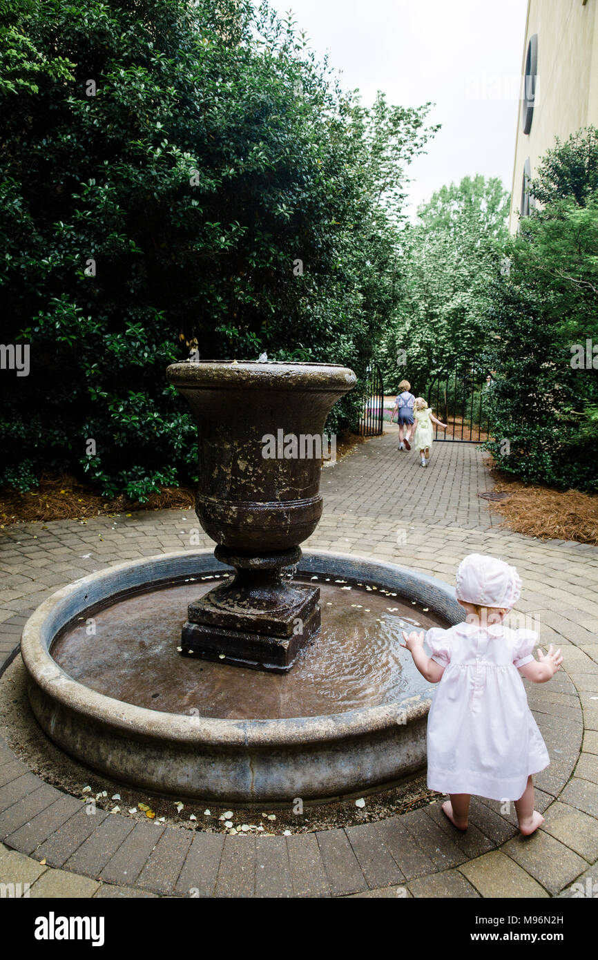 Baby and other children playing around fountain Stock Photo - Alamy