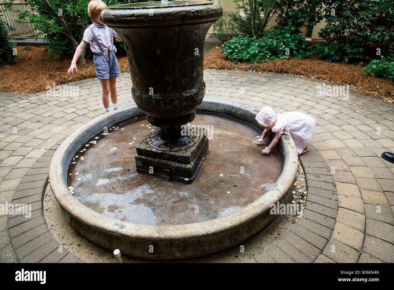 Baby and other children playing around fountain Stock Photo - Alamy