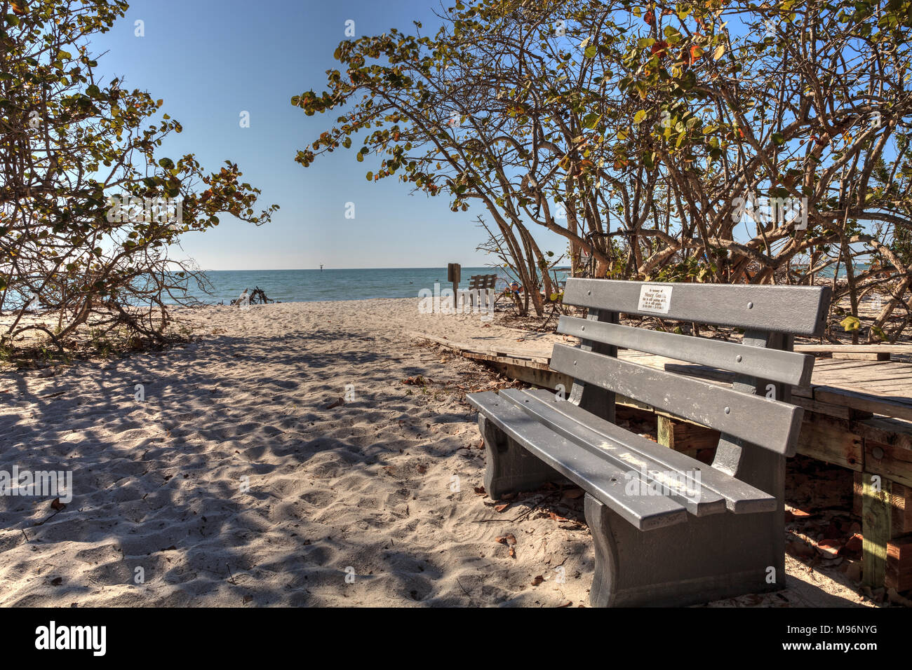 Wood bench on the white sand beach of Delnor-Wiggins Pass State Park ...