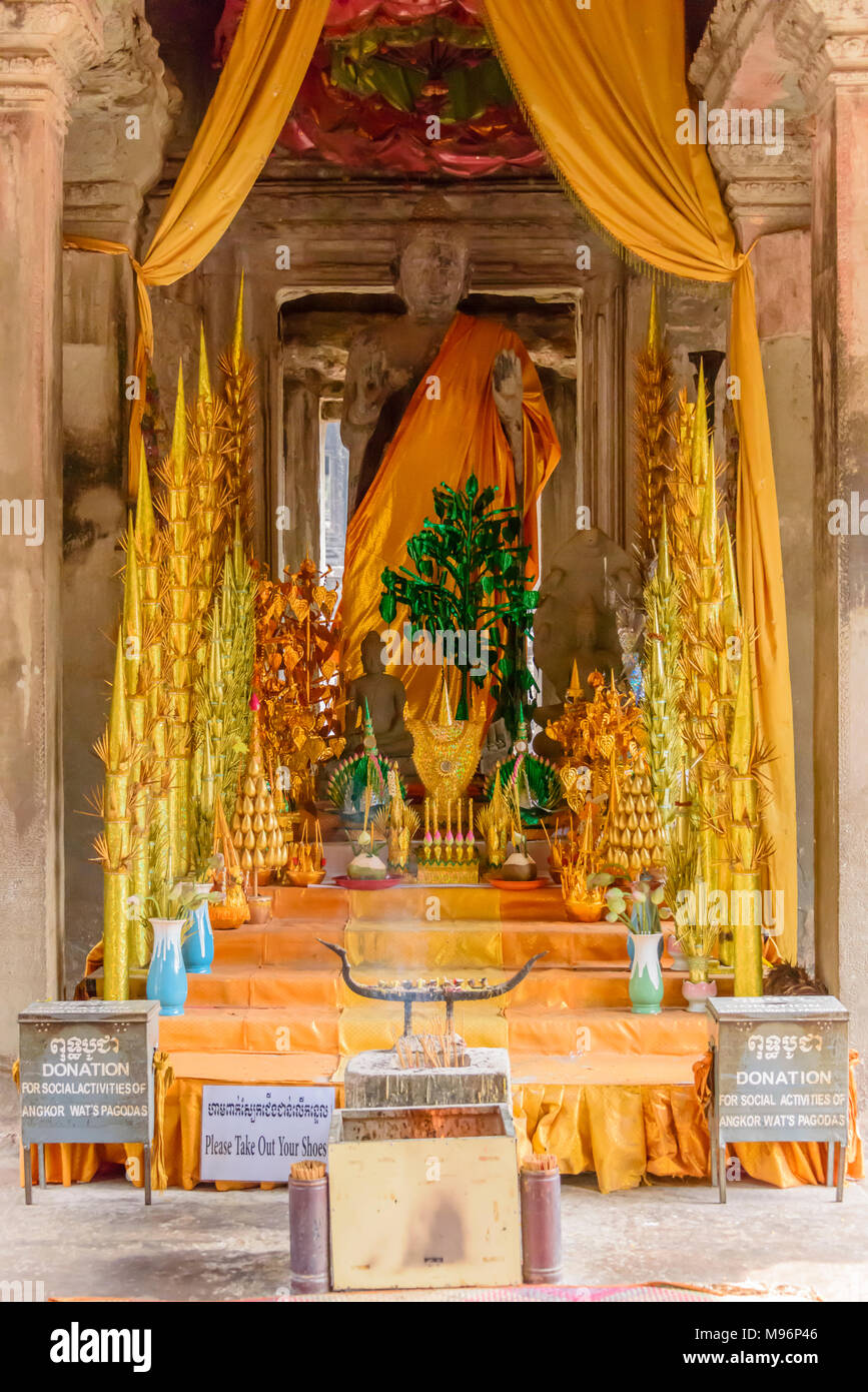 Statue of the Buddha wearing a saffron robe at an altar inside the ...