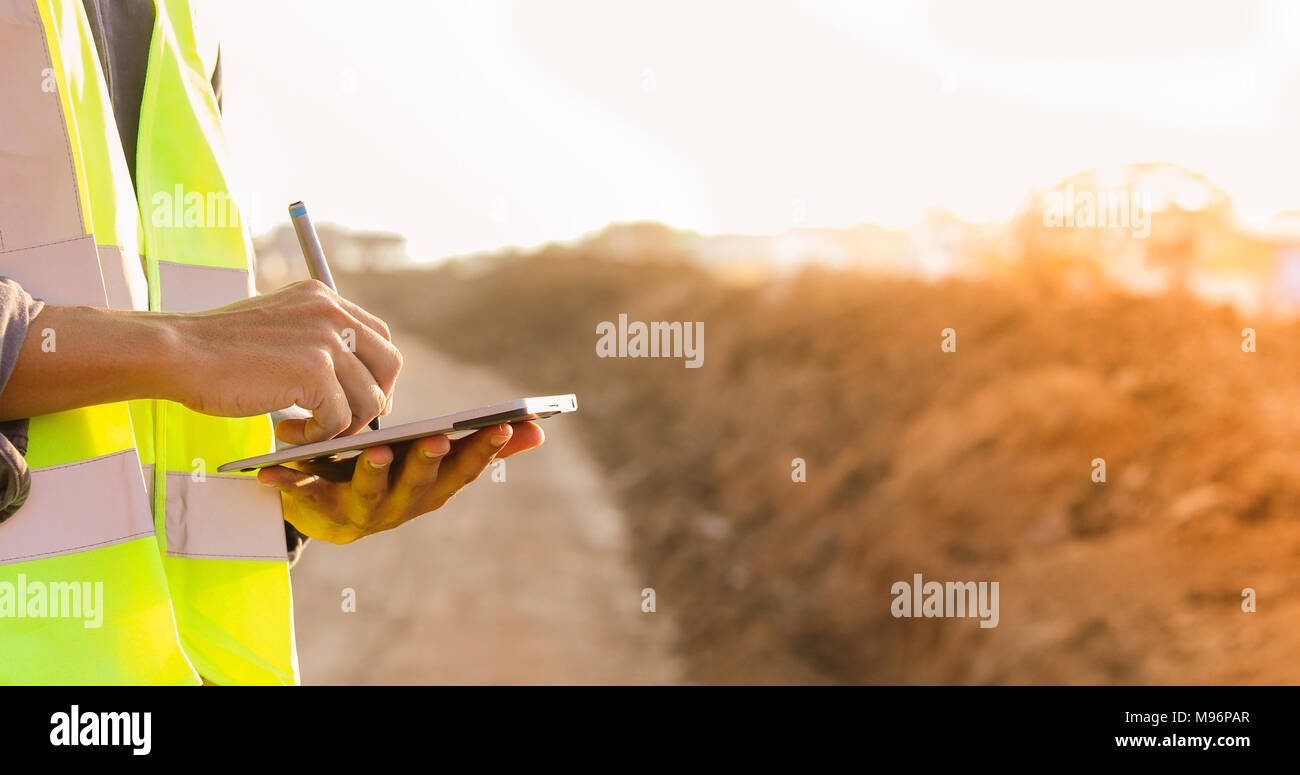 Asian engineer with hardhat using tablet pc computer inspecting and ...