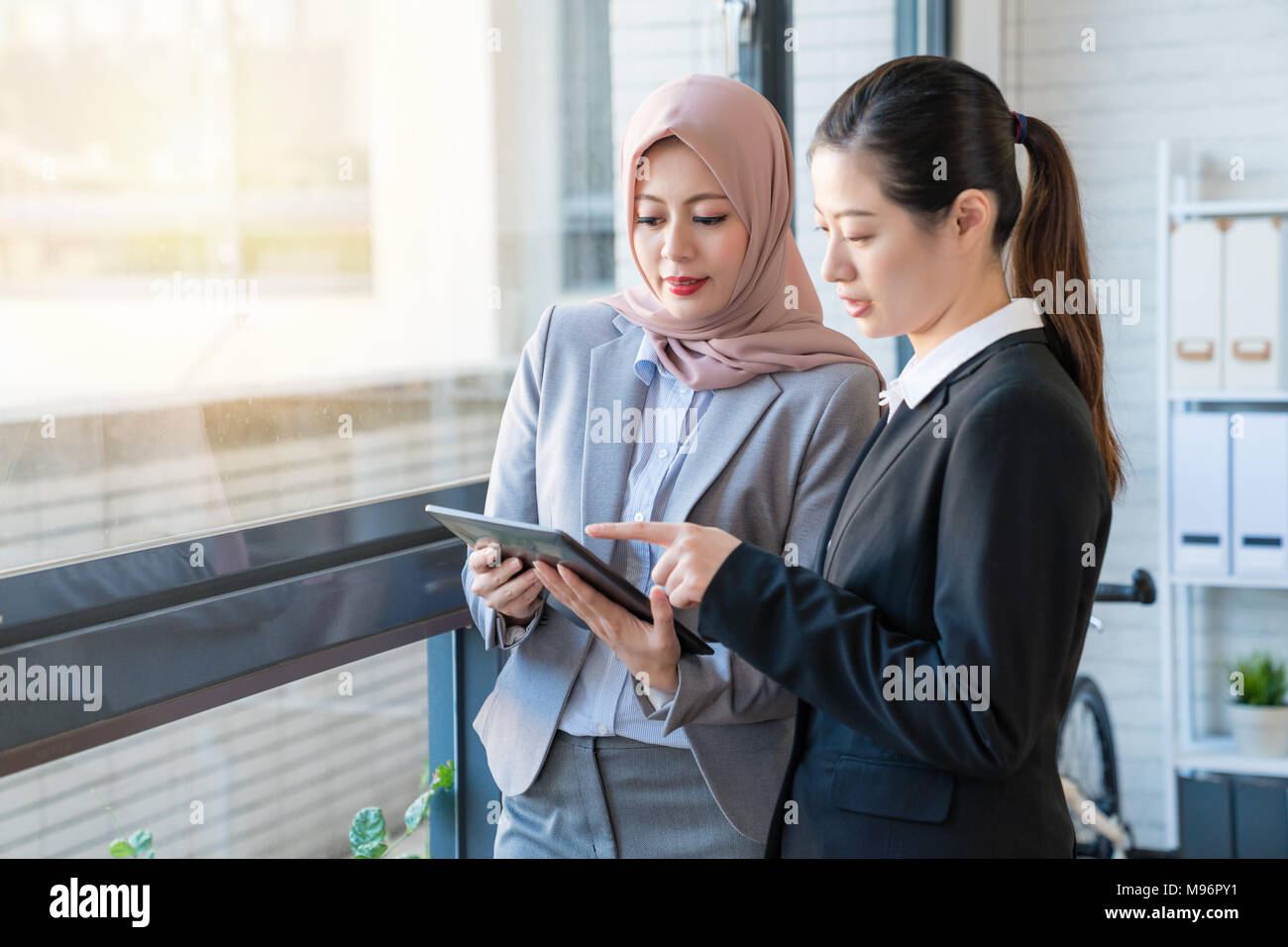 Muslim businesswoman listening to the report of her secretary. They are ...