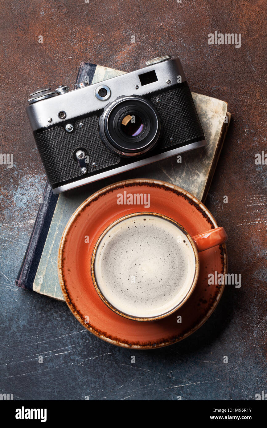 Coffee cup and retro camera over book. Top view Stock Photo - Alamy