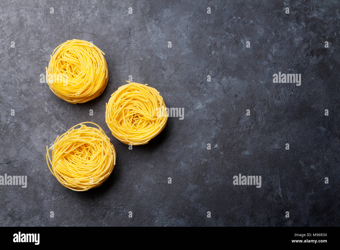 Nest pasta on stone cooking table. Top view with space for your recipe ...