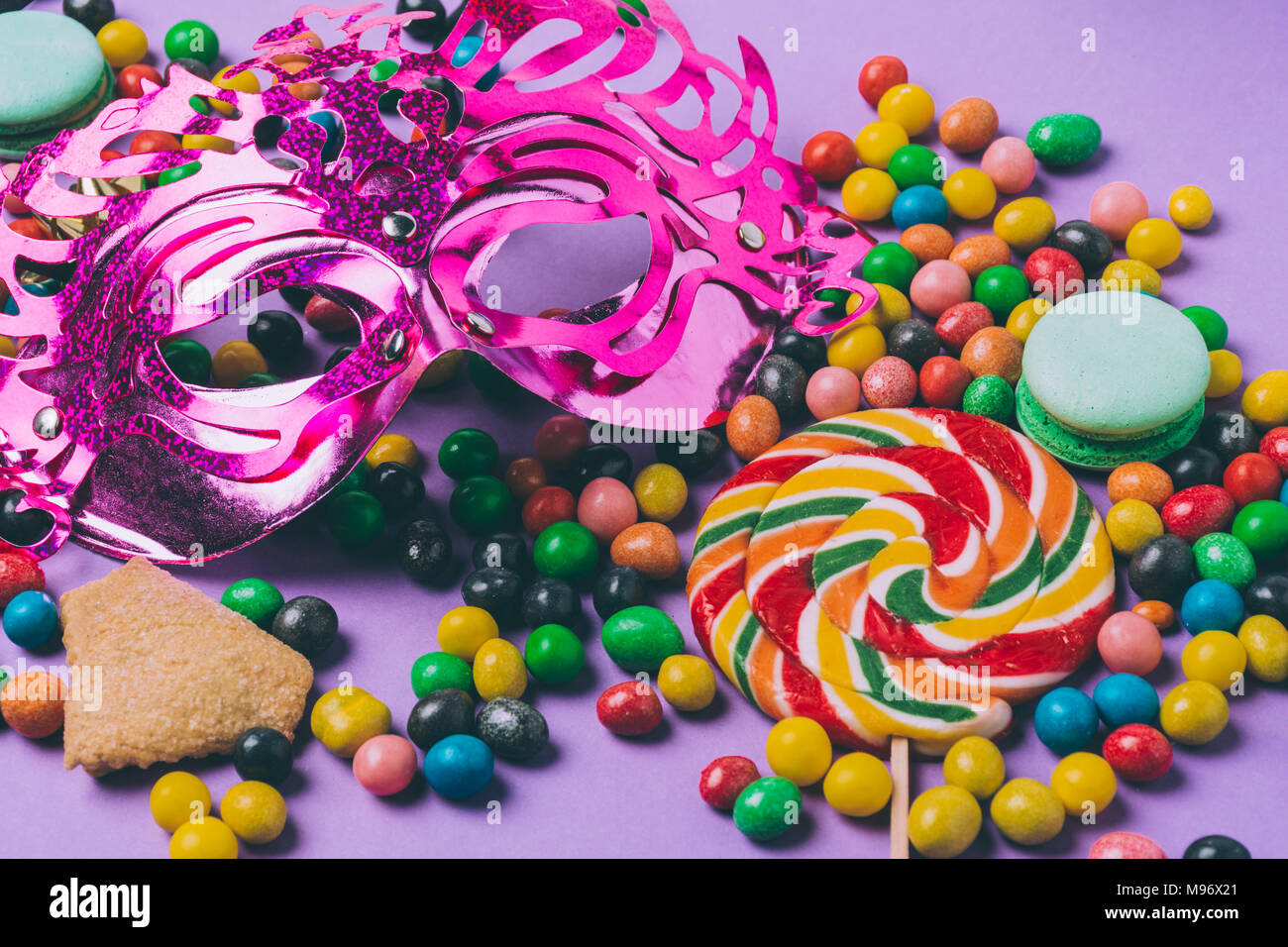 close up view of masquerade mask, lollipop and candies isolated on ...