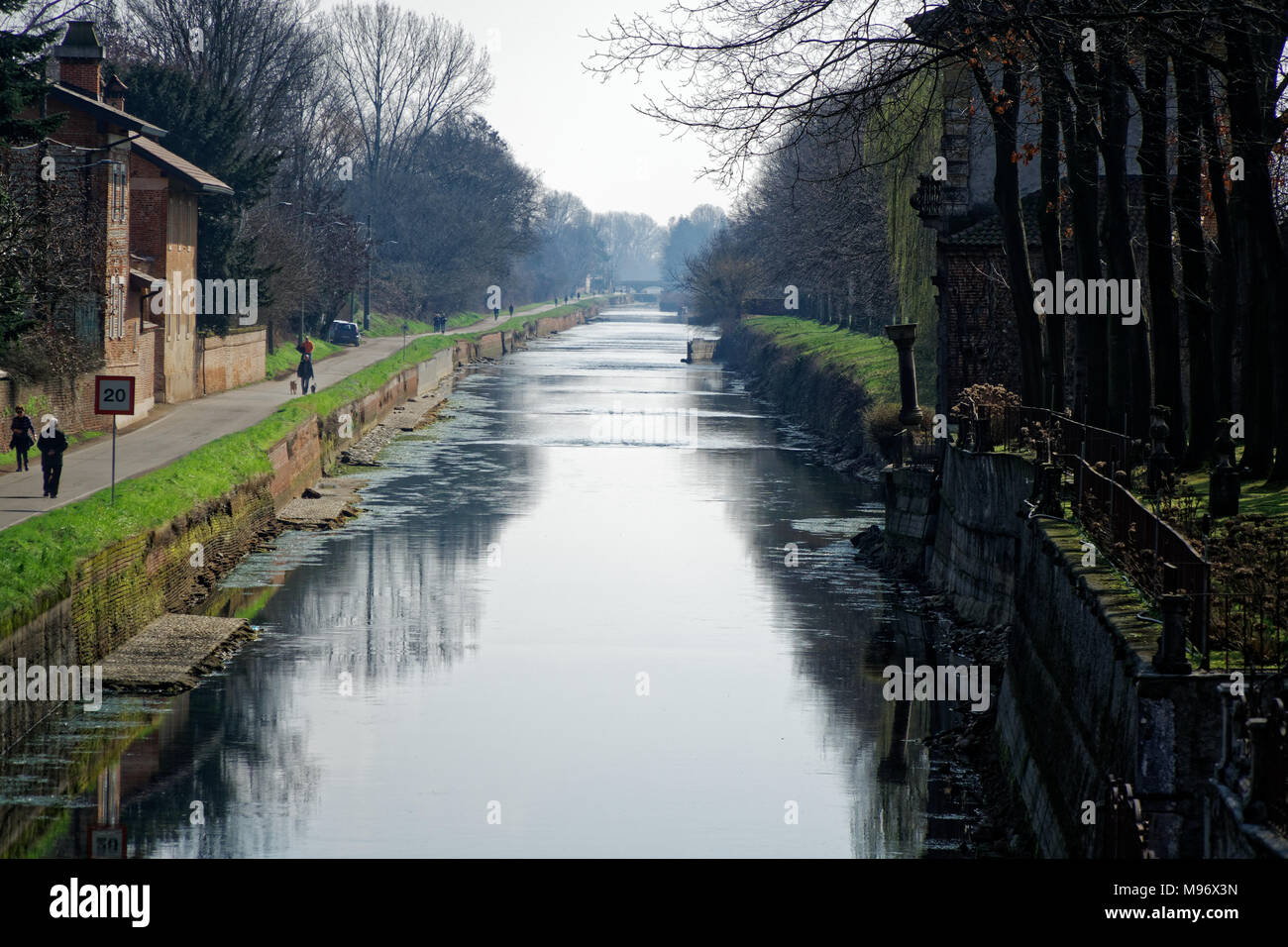Water canal in spring day, sidewalk along river bank Stock Photo - Alamy