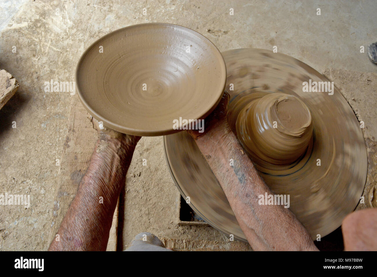 Kashmiri potter earthen pot on a traditional potter’s wheel at his ...