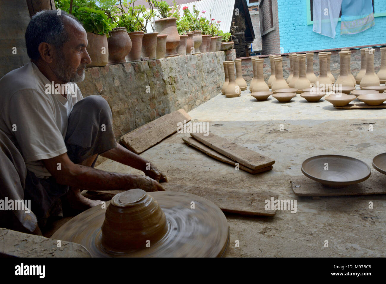 Kashmiri potter earthen pot on a traditional potter’s wheel at his ...