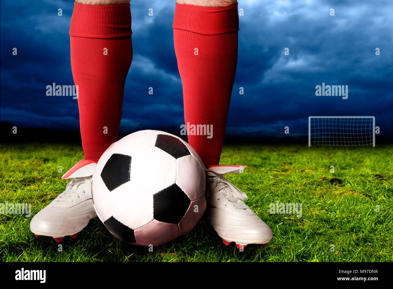 football player legs and ball standing on the pitch Stock Photo - Alamy