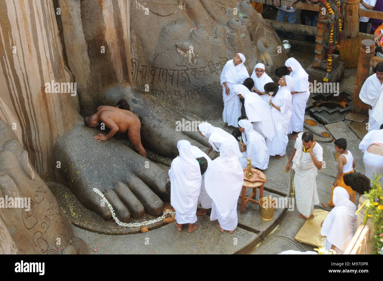Jain devotees at the foot of gomateshvara bahubali statue ...