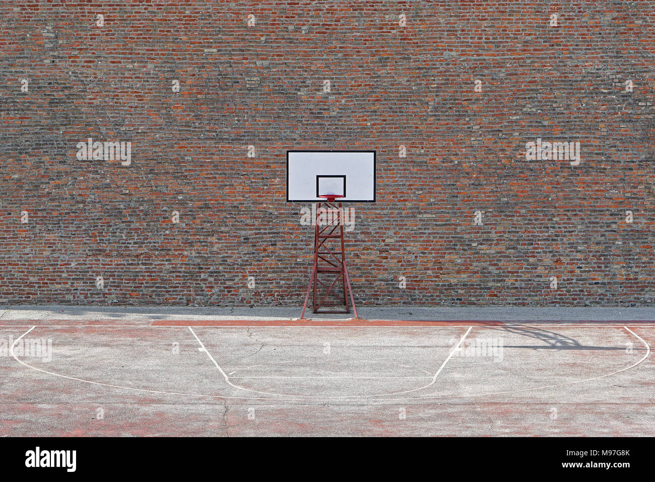Basketball court with one hoop in front of brick wall Stock Photo - Alamy