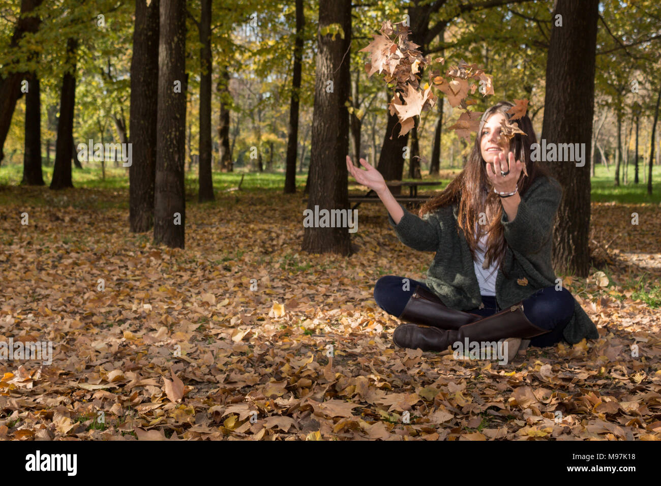 Girl throwing leaves in the forest in autumn Stock Photo - Alamy