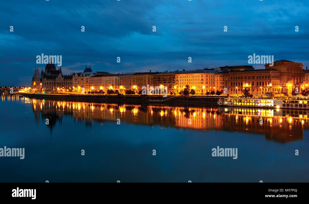Pest downtown riverfront at night, reflecting in still Danube water ...