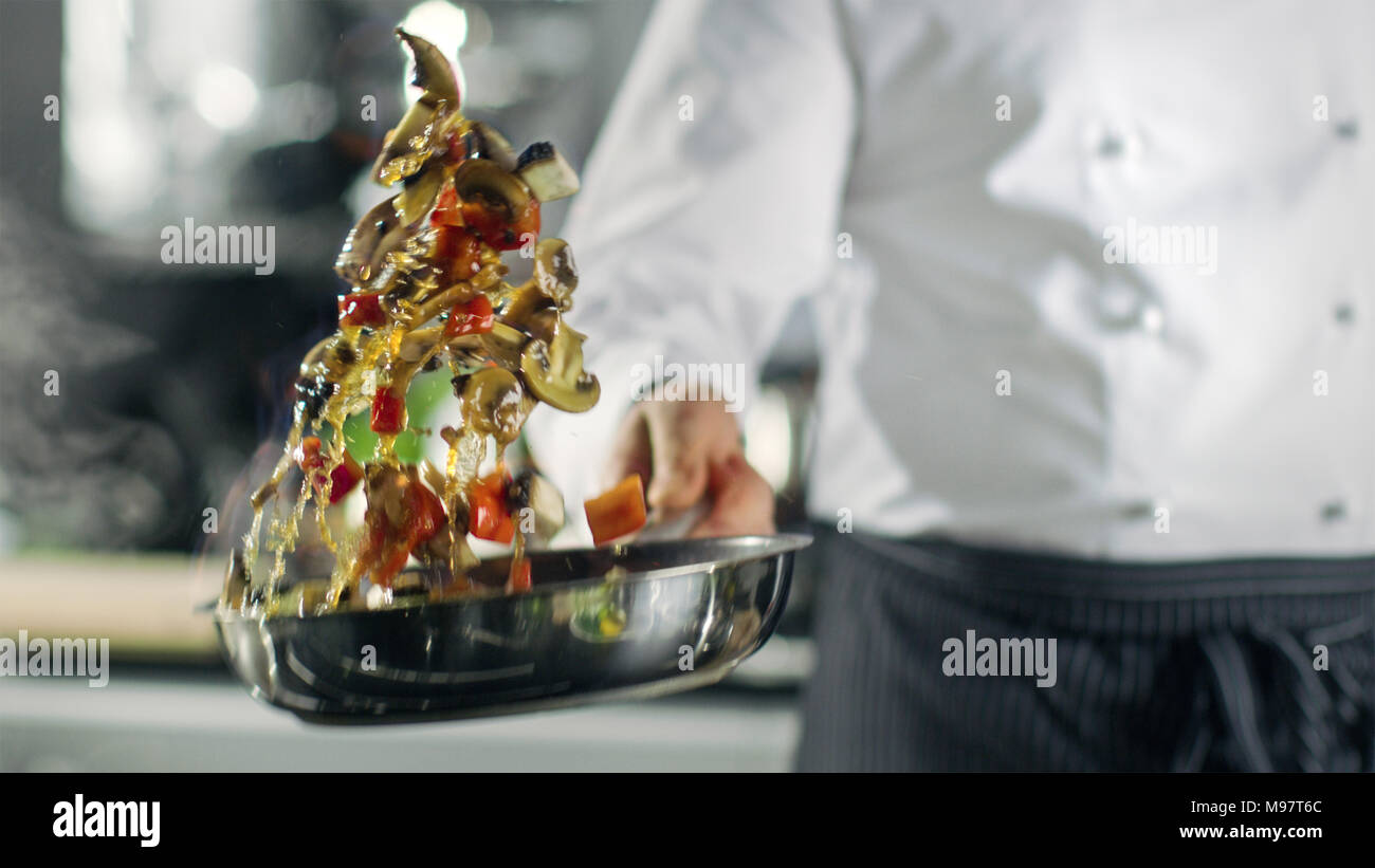 Professional Chef Cooks Flambe Style. He Prepares Dish in a Pan with ...