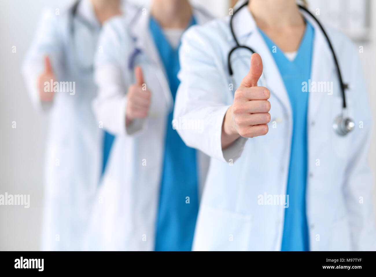 Groupe of medicine doctors show OK sign with thumb up close up. Success ...