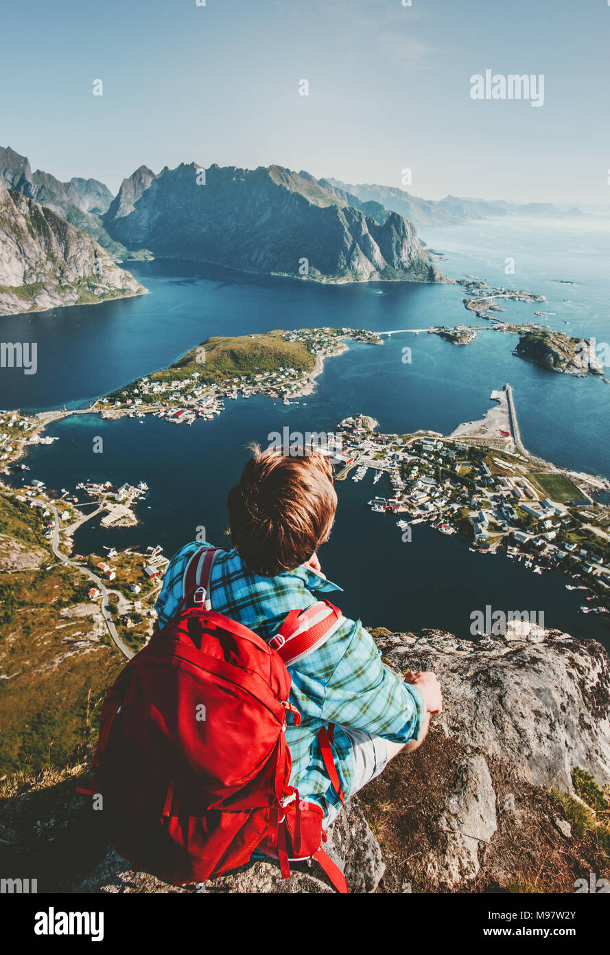 Man traveling in Norway sitting on cliff edge lifestyle adventure ...
