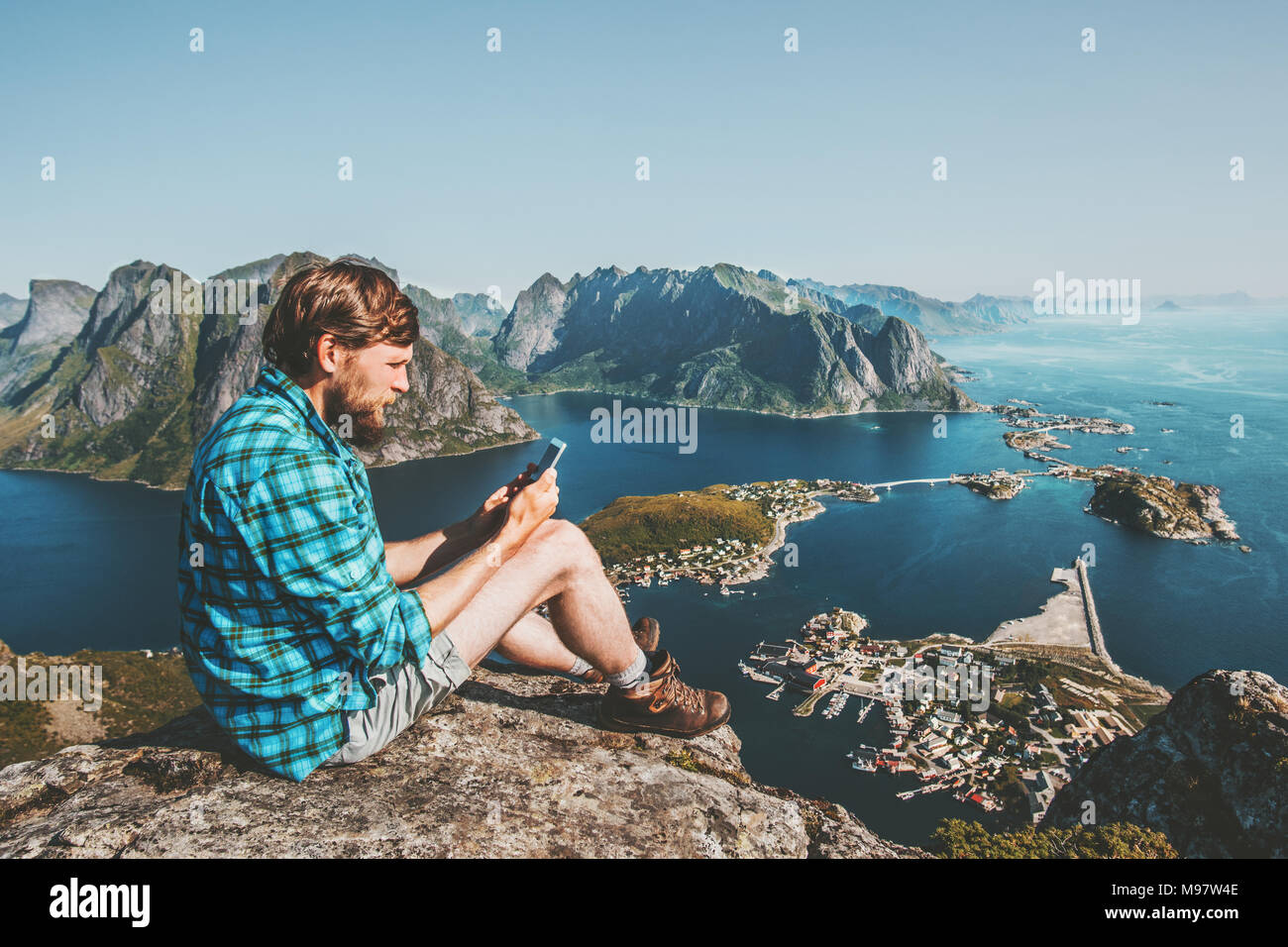 Man tourist using smartphone sitting on cliff edge Traveling lifestyle ...