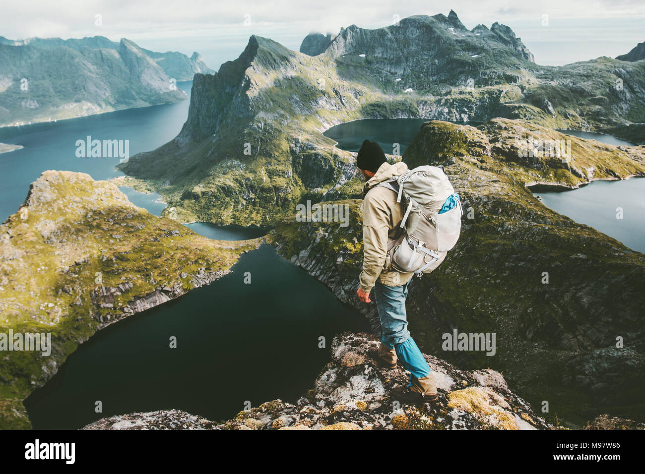 Discoverer man standing on cliff mountain in Norway Traveling lifestyle ...
