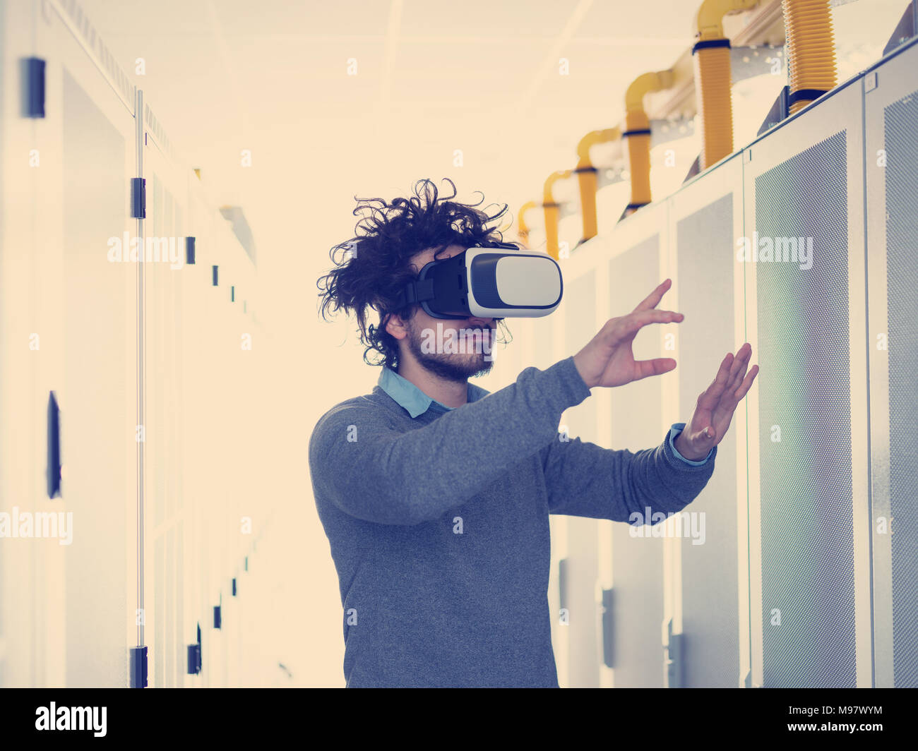 young IT engeneer using virtual reality headset over server room ...