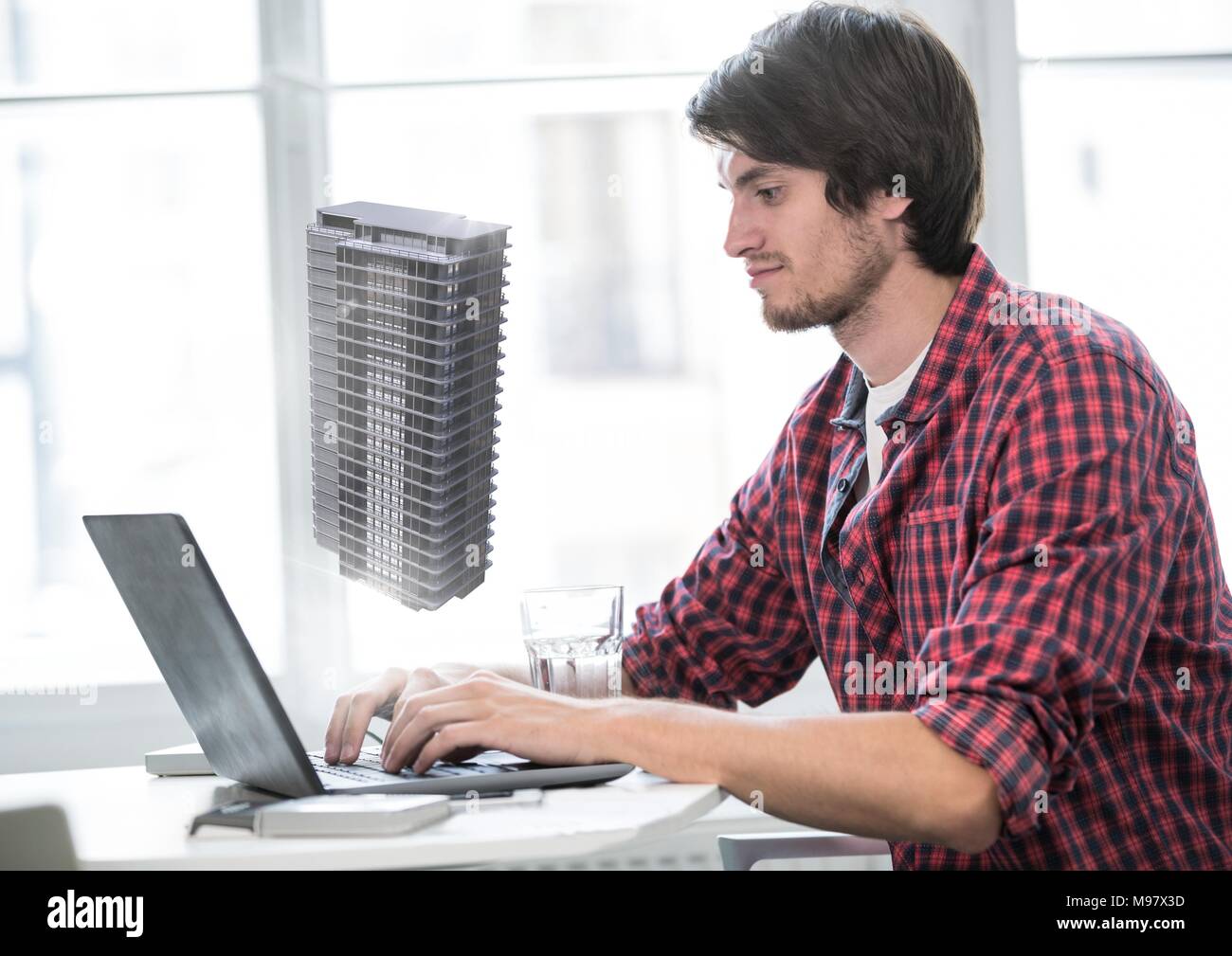 Man typing on laptop with 3D architecture building model Stock Photo ...