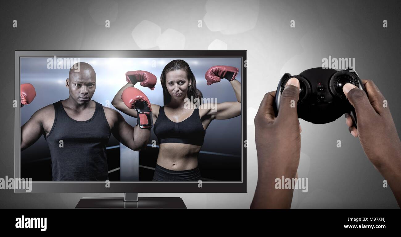 Hands holding gaming controller with boxing fighters on television ...