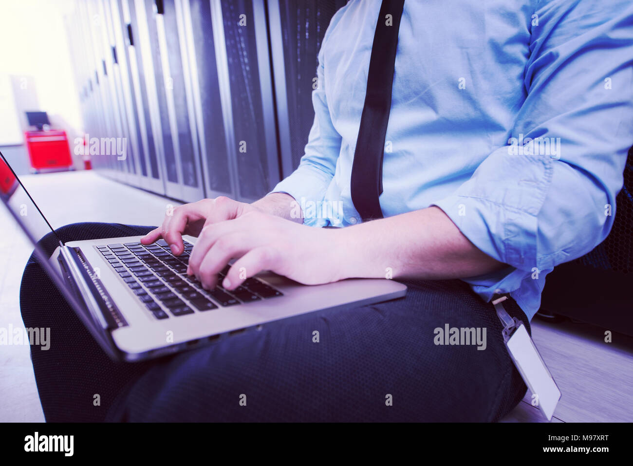 Male IT engineer working on a laptop in server room at modern data ...