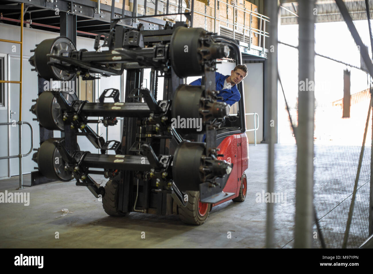 Worker moving equipment riding forklift Stock Photo - Alamy