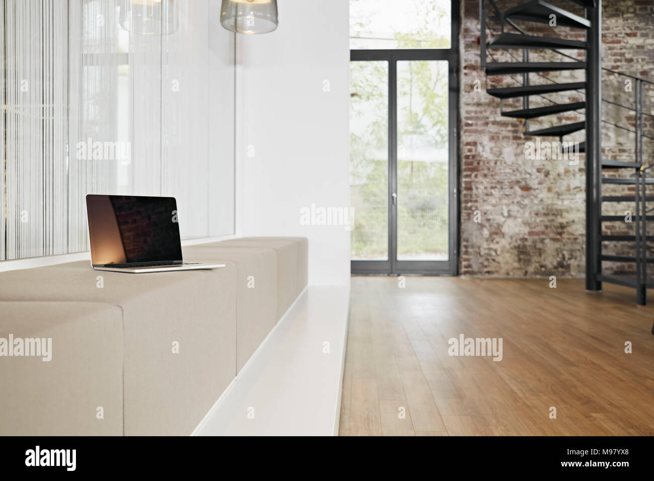 Laptop on bench in modern office Stock Photo - Alamy