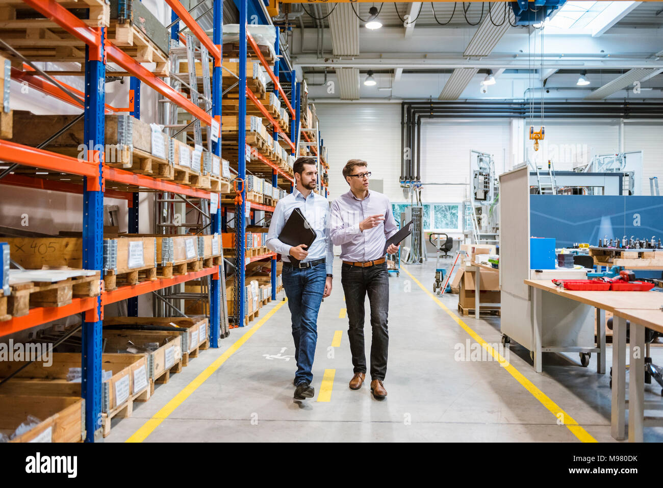 Two men walking in factory Stock Photo - Alamy