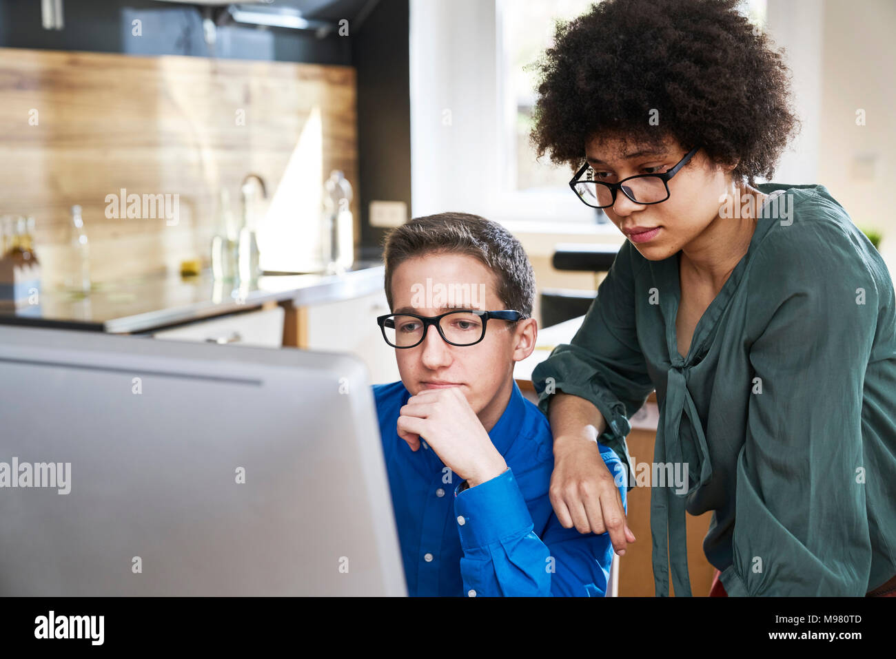 Two colleagues looking at computer monitor in office Stock Photo - Alamy