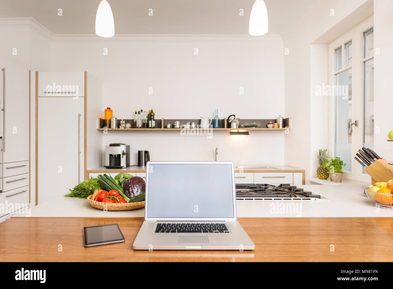 Laptop and tablet on kitchen counter Stock Photo - Alamy