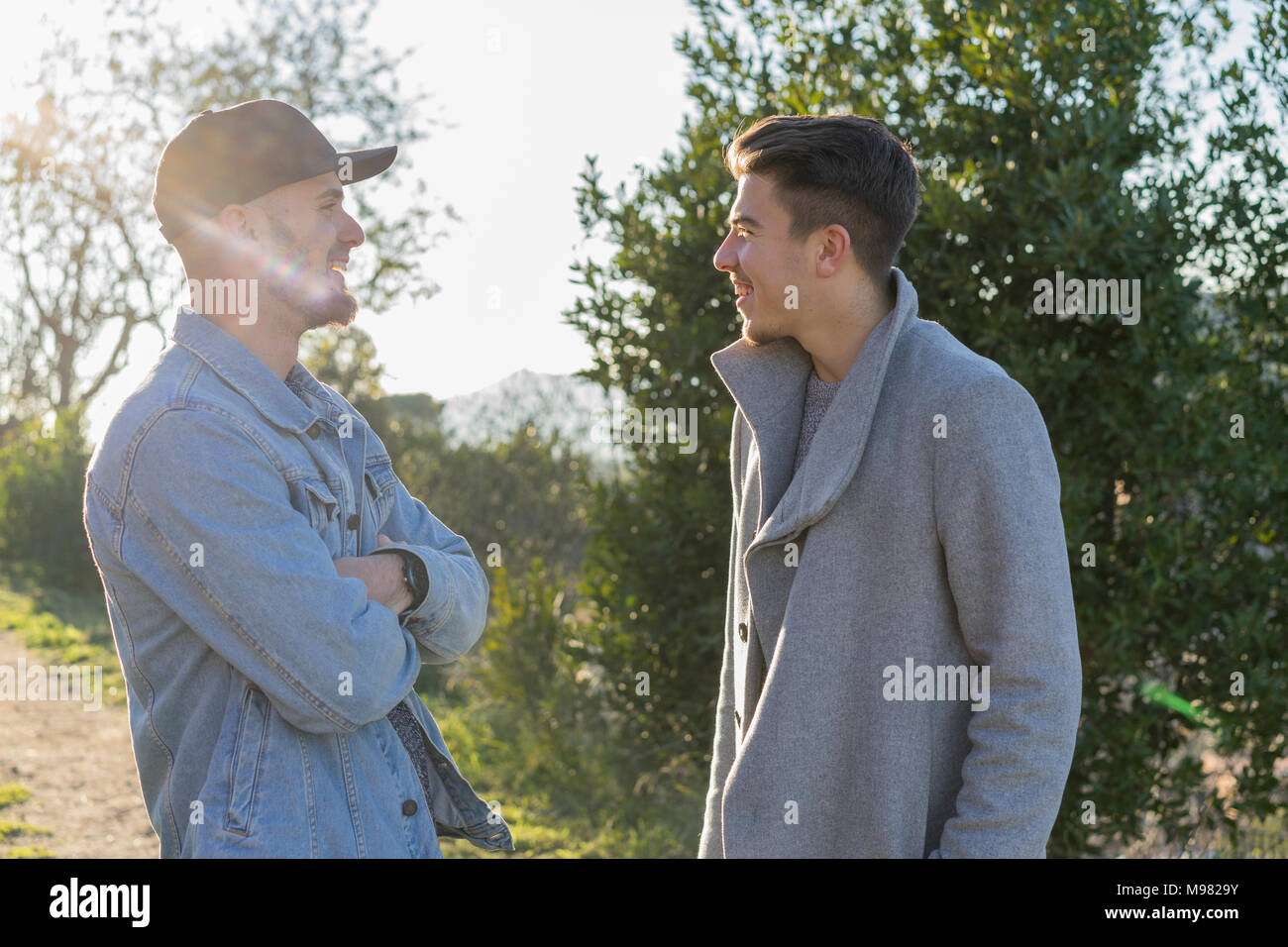 Two happy friends talking outdoors Stock Photo - Alamy