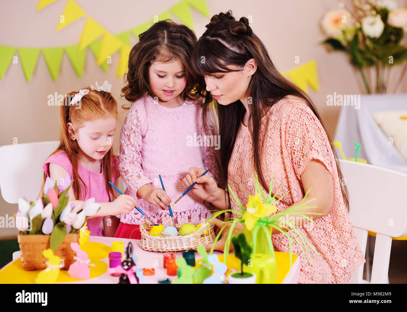 young woman mother with little girls daughters preparing for the ...