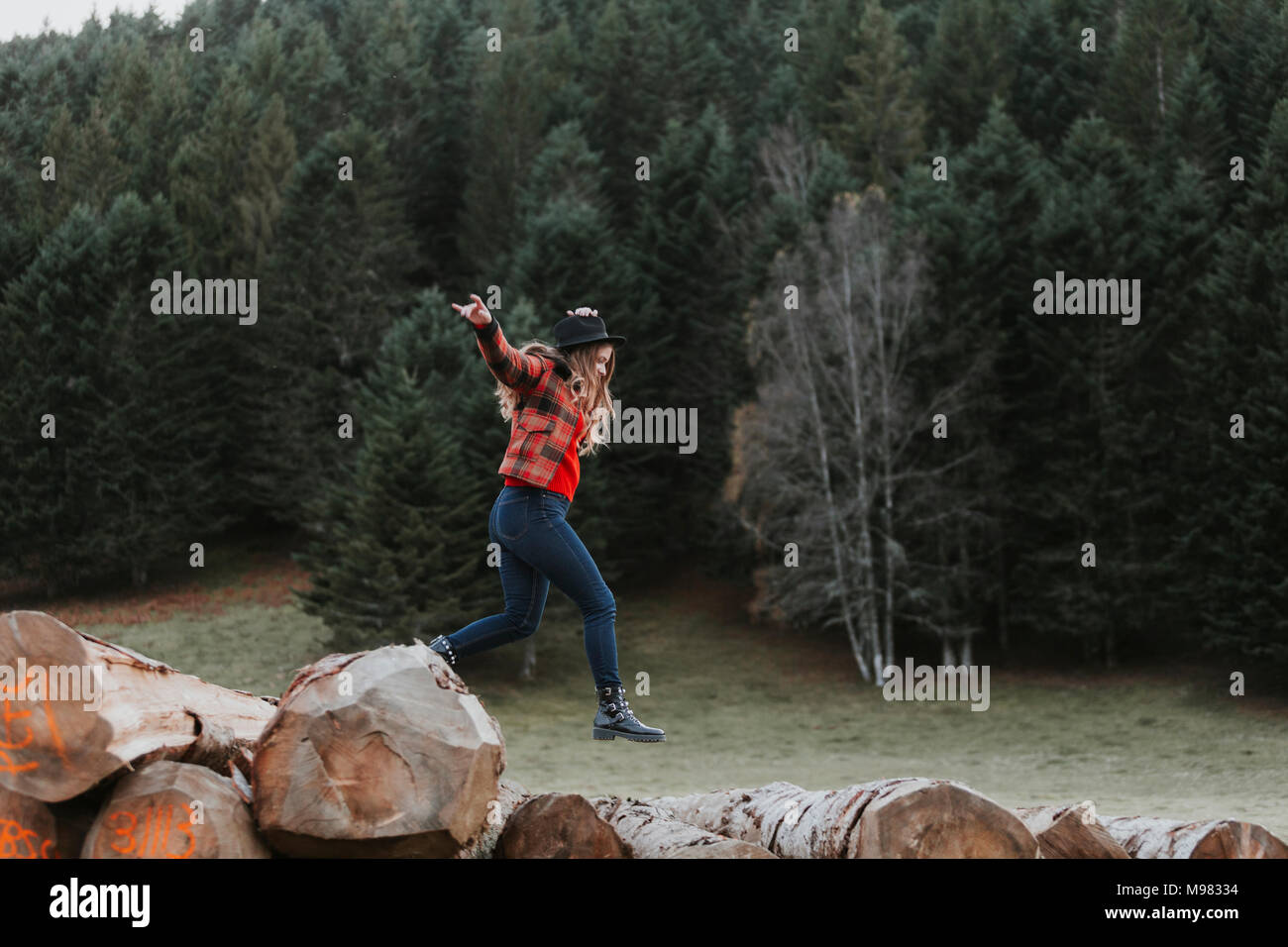 Young woman balancing on logs Stock Photo - Alamy