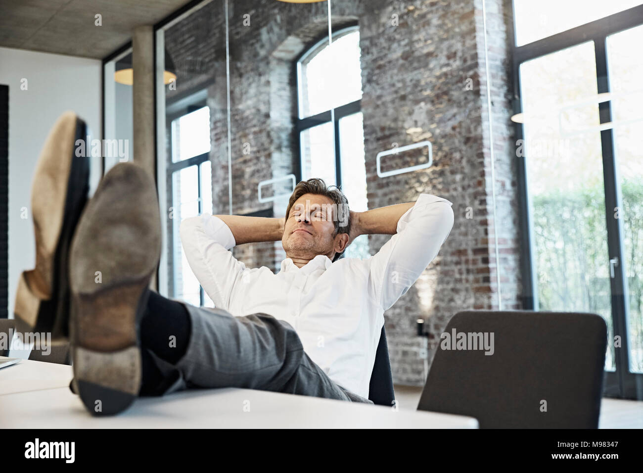 Mature businessman relaxing in conference room of modern office Stock ...