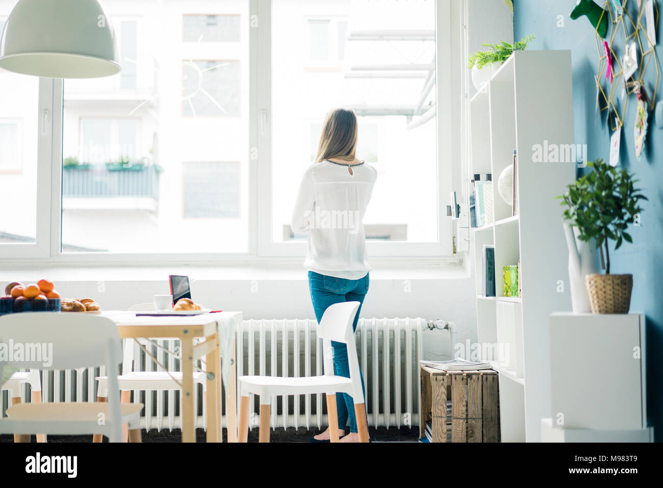 Back view of woman looking out of window Stock Photo - Alamy