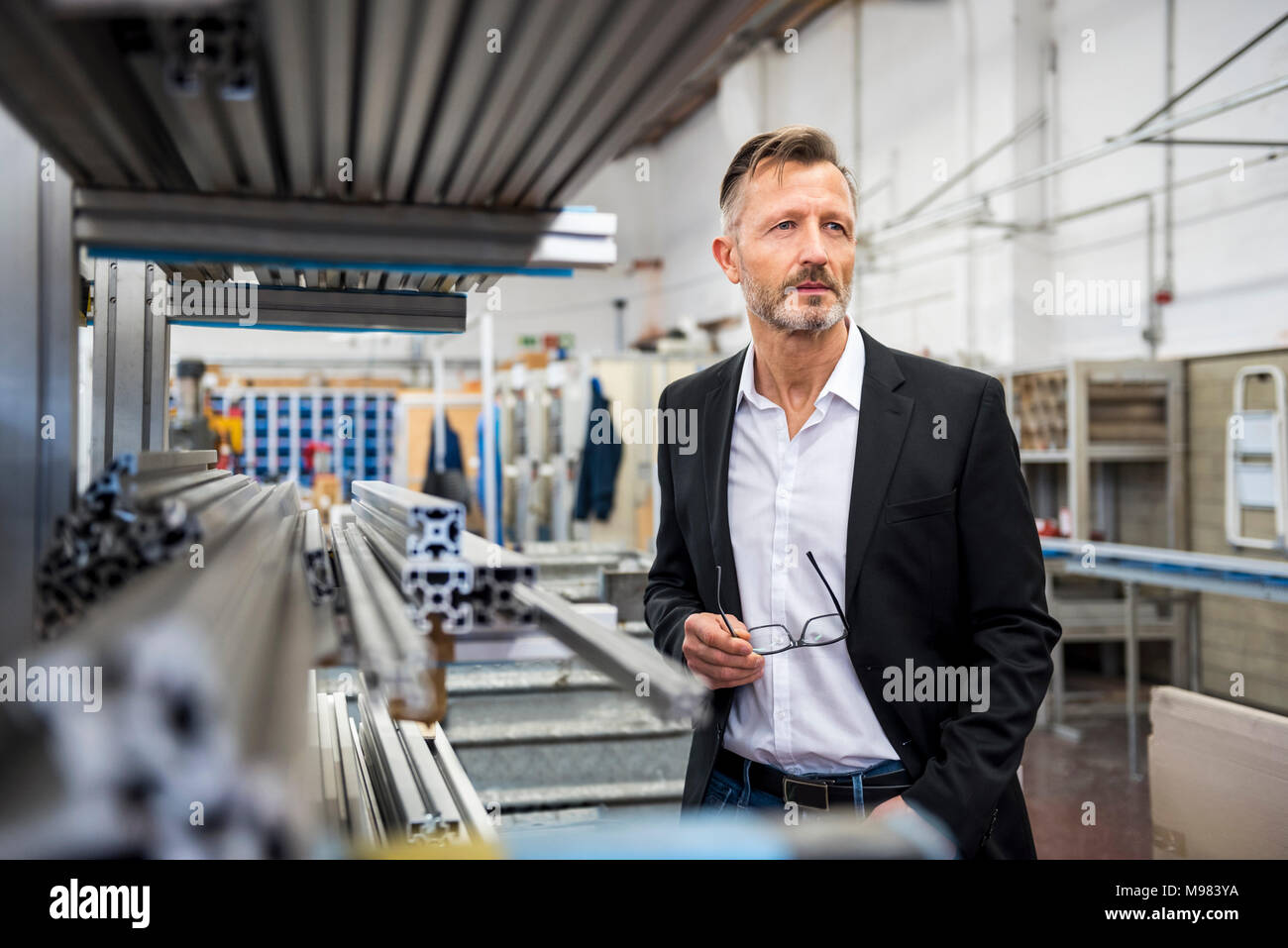 Mature businessman in factory thinking Stock Photo - Alamy