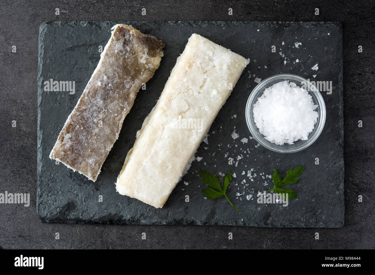 Salted dried cod on black stone top view. Typical Easter food Stock ...