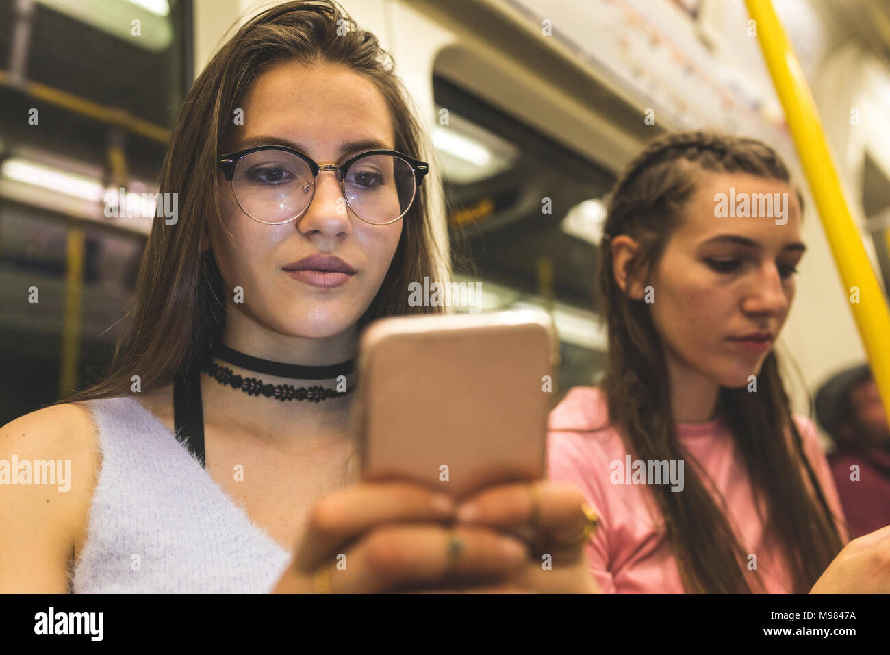 Teenage girl using cell phone in subway Stock Photo - Alamy