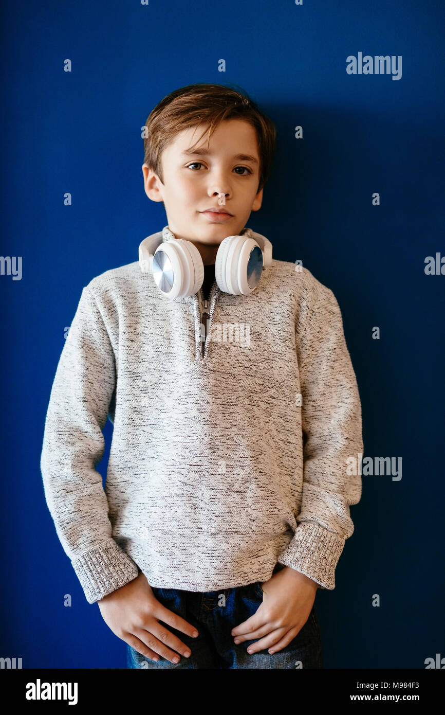 Portrait of boy wearing headphones at blue wall Stock Photo - Alamy