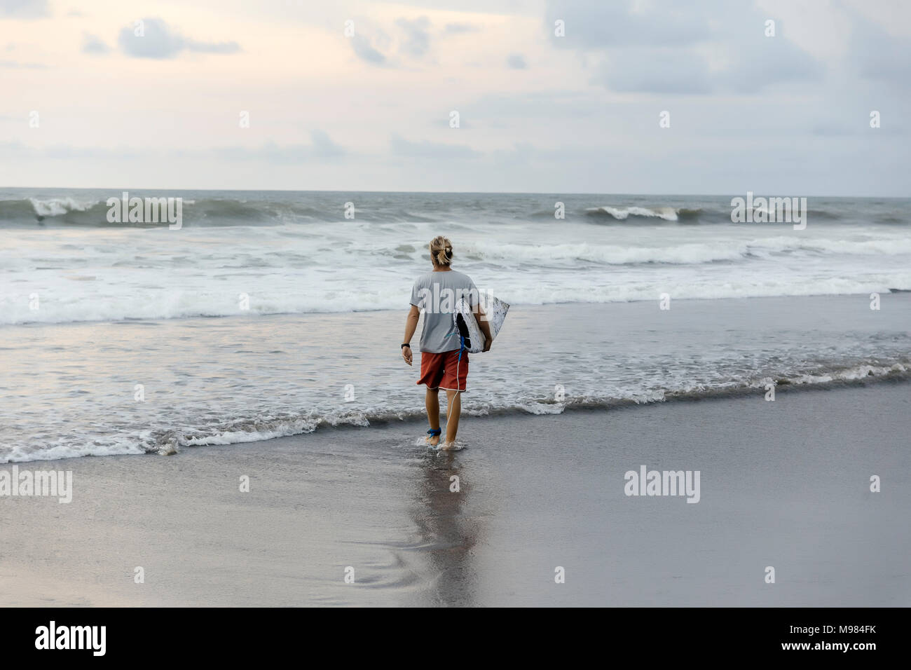 Indonesia, Bali, surfer walking into water Stock Photo - Alamy