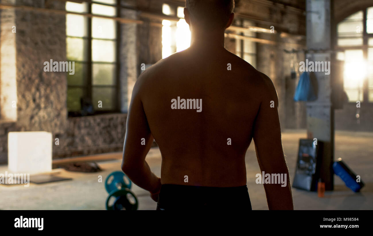 Shot from the back of Muscular Shirtless Man Entering Gym. He's ...