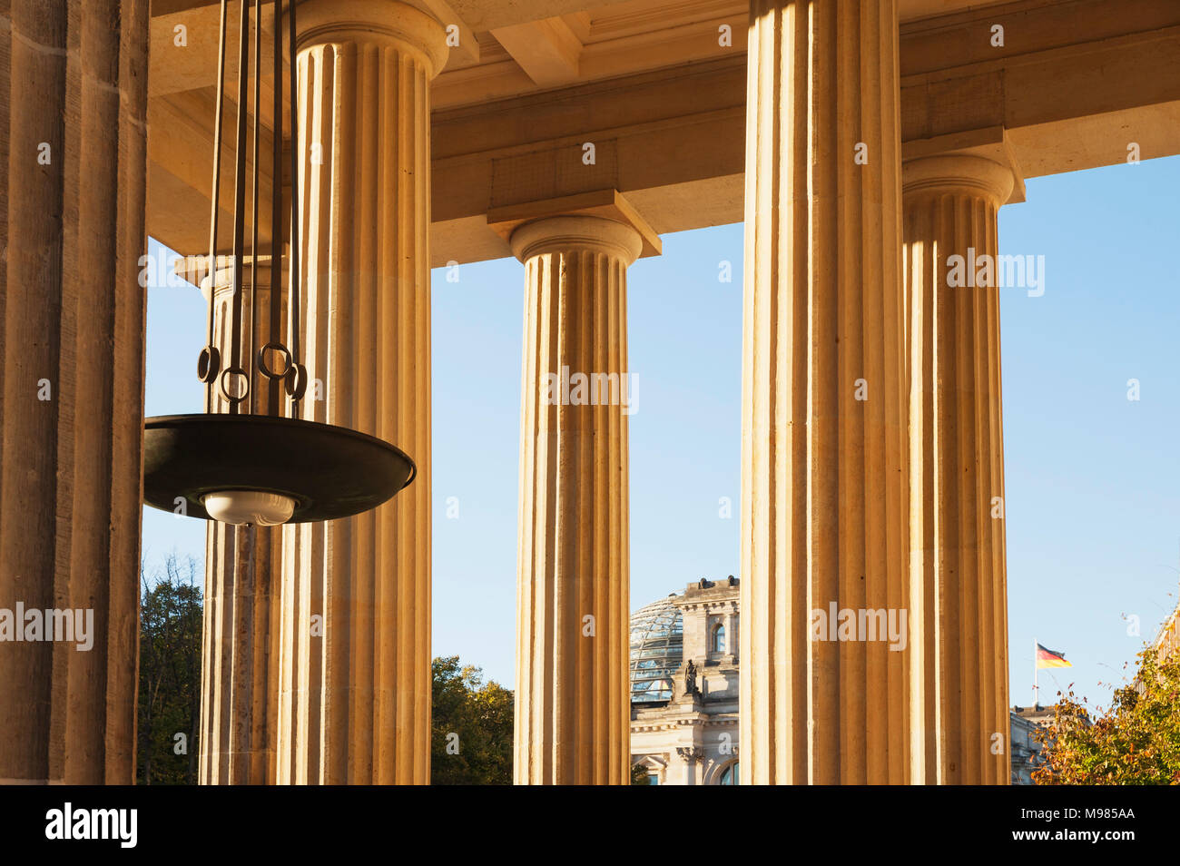 Germany, Berlin, columns of Brandenburger Tor, Reichstag building in ...